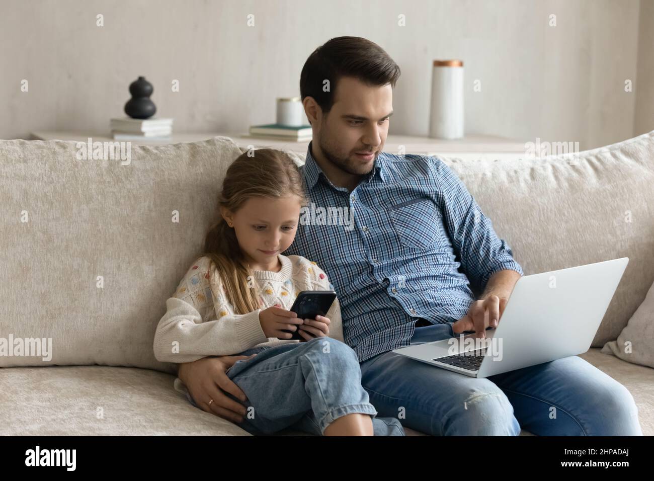 Focused dad and daughter kid engaged in gadgets using Stock Photo - Alamy