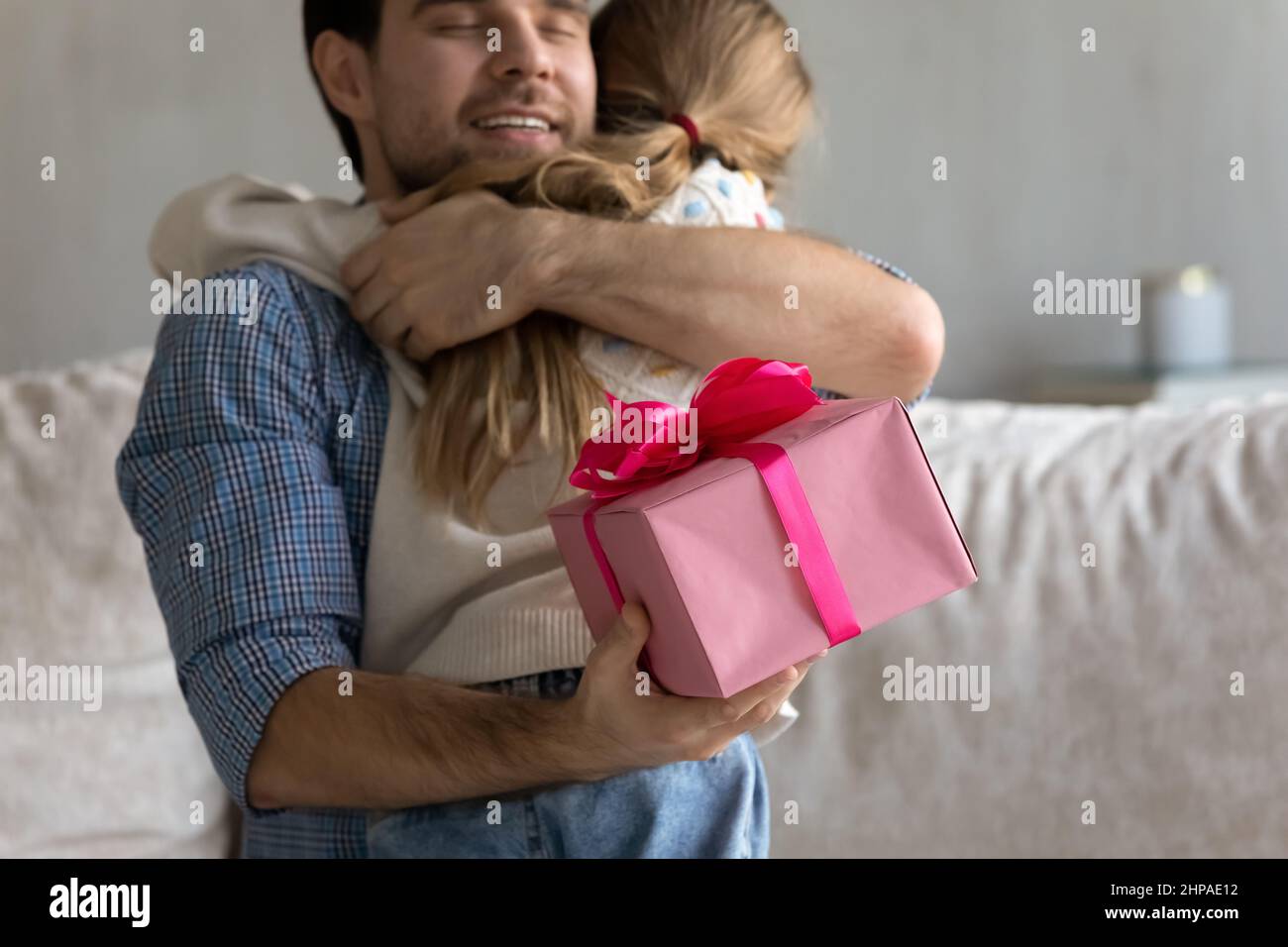 Happy grateful devoted dad hugging little daughter girl with gratitude ...