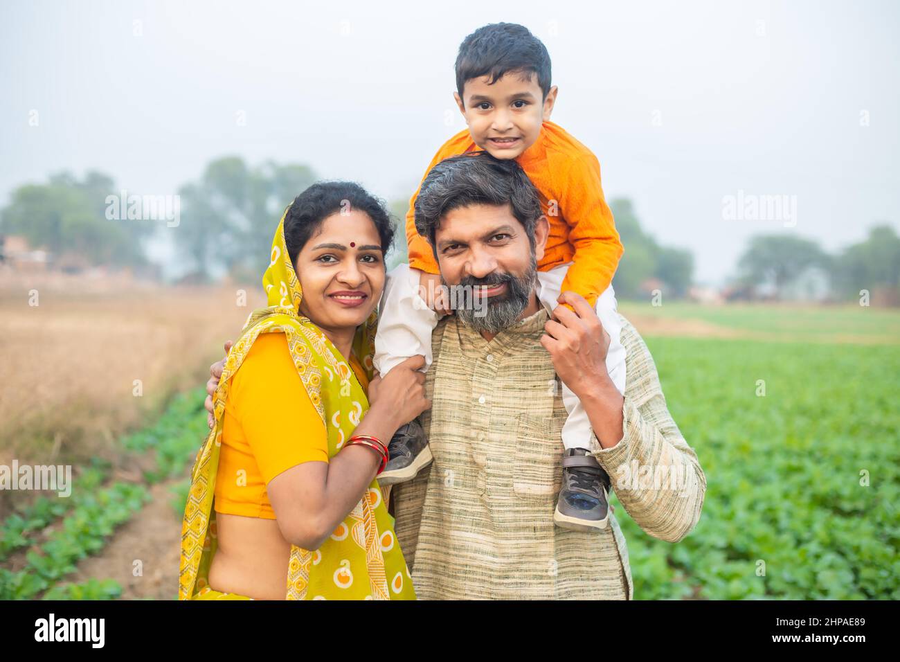 Portrait happy traditional Indian family at agricultural field, Smiling ...