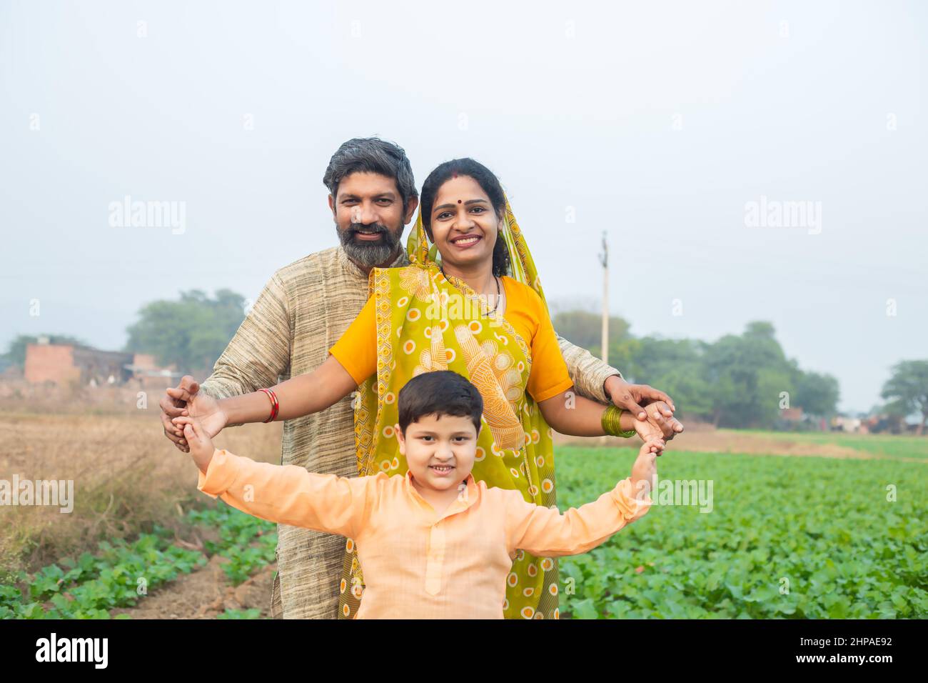 Portrait happy traditional Indian family at agricultural field, Smiling ... Portrait happy traditional Indian family at agricultural field, Smiling ...