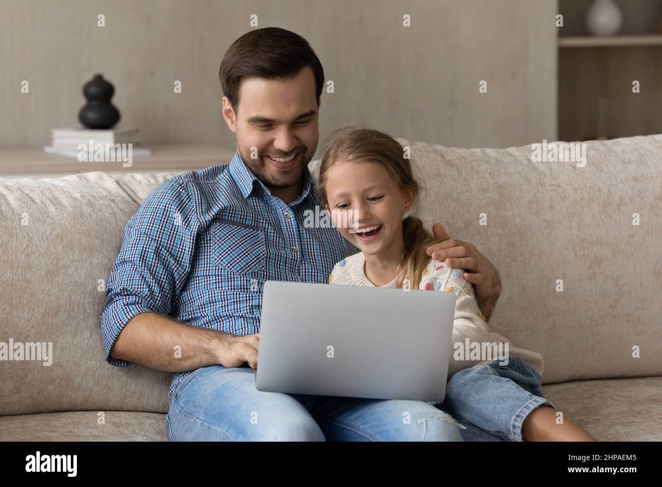 Happy daddy and cheerful daughter kid relaxing on couch Stock Photo - Alamy