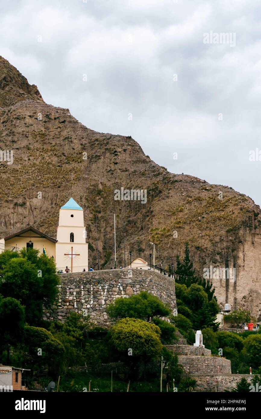 Three storey church building with mountains and cloudy sky on the ...
