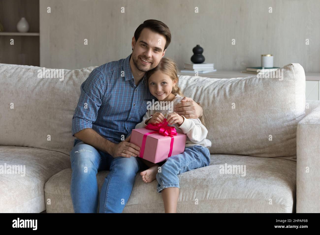 Happy affectionate dad giving surprise birthday gift to little daughter ...