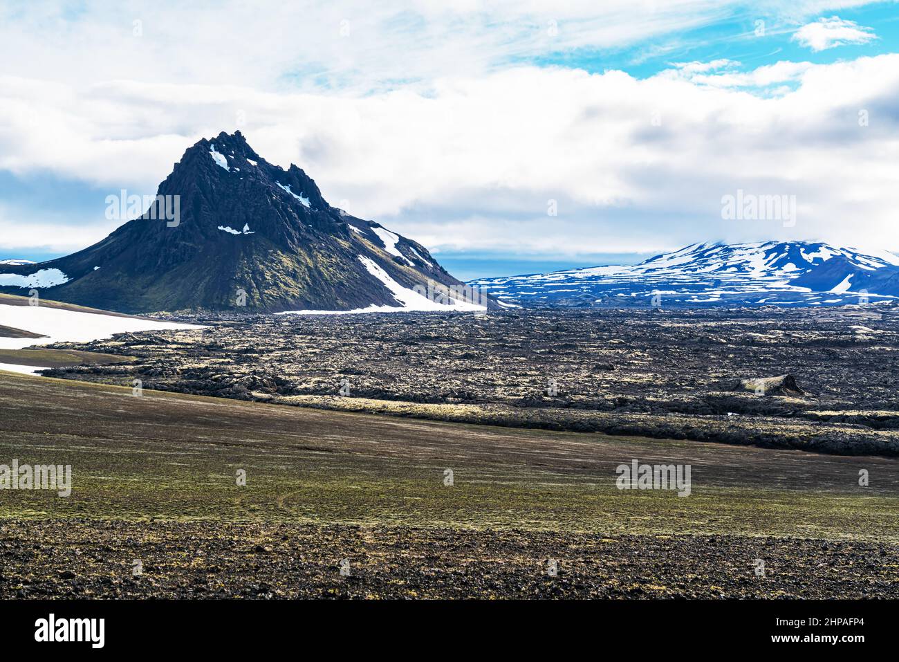 Beautiful volcanic landscape with snow covered mountain and rough lava ...