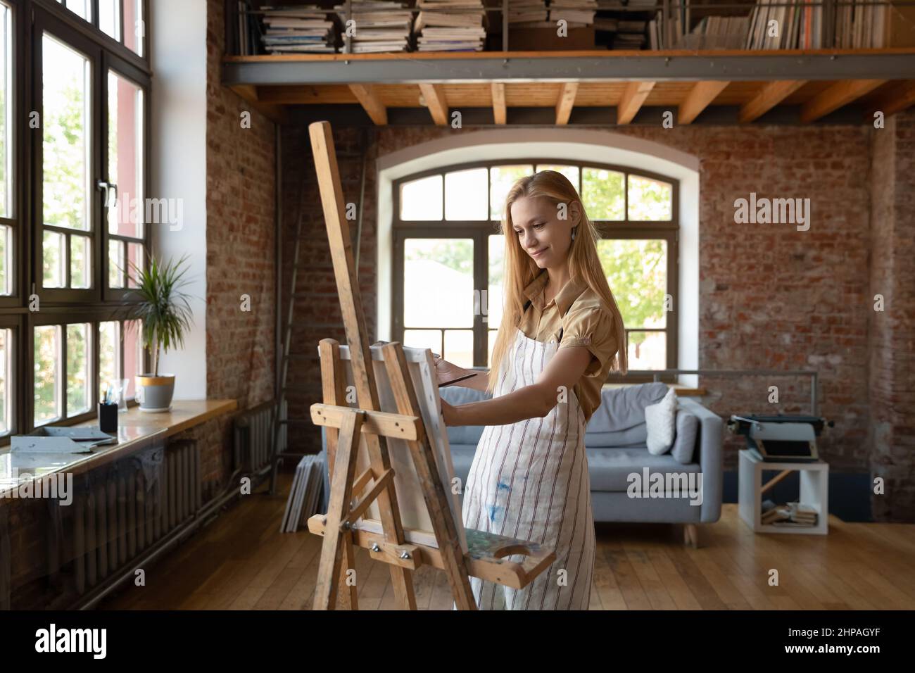 Happy skilled young female artist working on new artwork Stock Photo ...