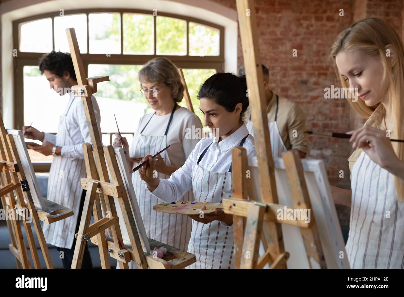 Happy focused diverse people drawing on canvas Stock Photo - Alamy