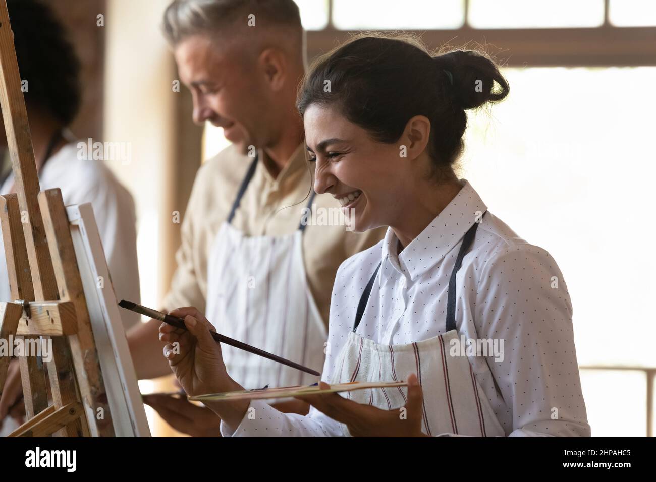 Joyful laughing young Indian woman drawing on easel Stock Photo - Alamy