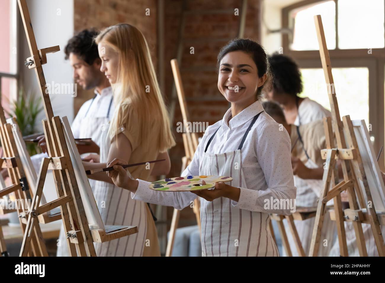 Portrait of smiling motivated Indian woman doing artwork Stock Photo ...