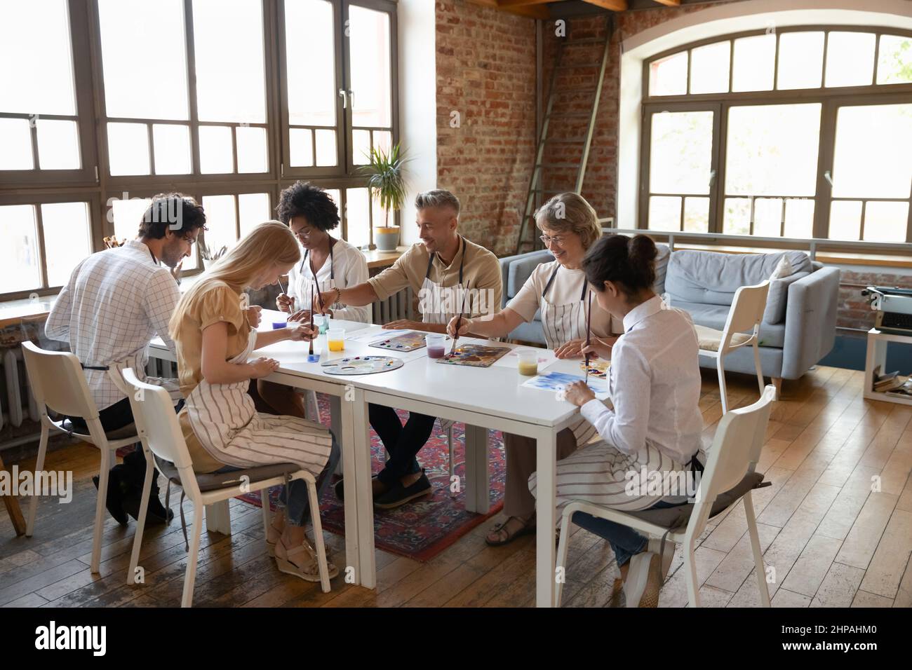 Happy group of motivated diverse people enjoying painting master class ...
