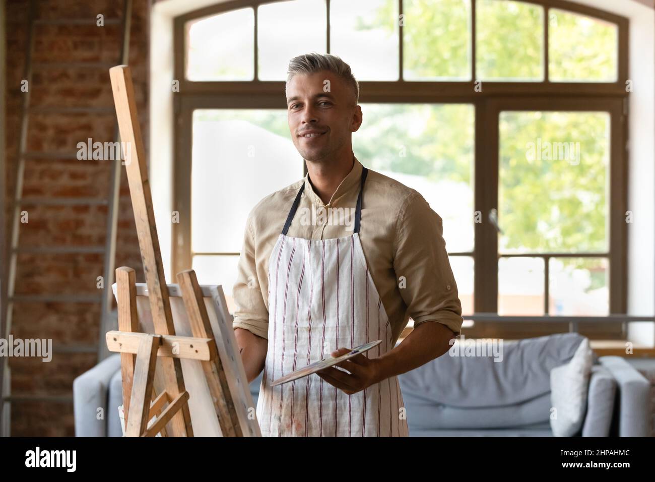 Portrait of handsome 40s man drawing on canvas Stock Photo - Alamy