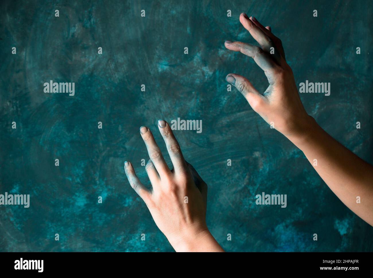 Female hands are stained with blue paint against a blue wall Stock ...