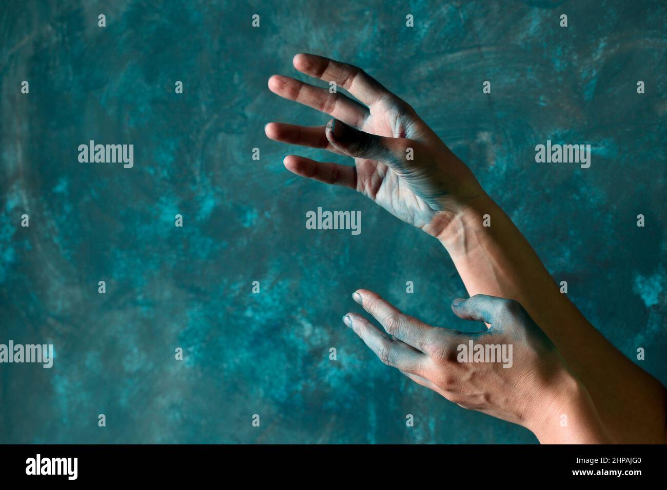 Female hands are stained with blue paint against a blue wall Stock ...