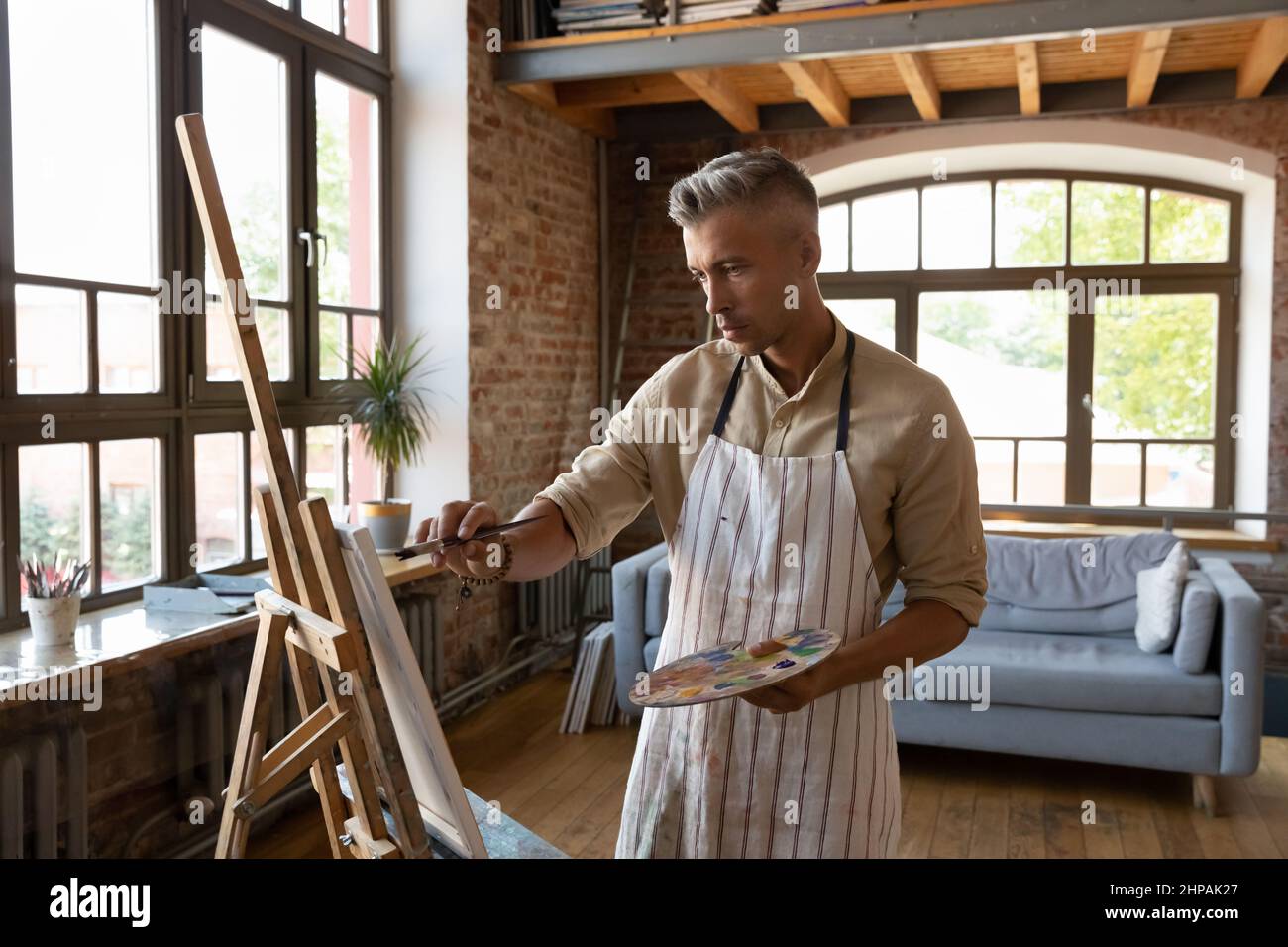 Focused skilled male artist creating artwork in studio Stock Photo - Alamy