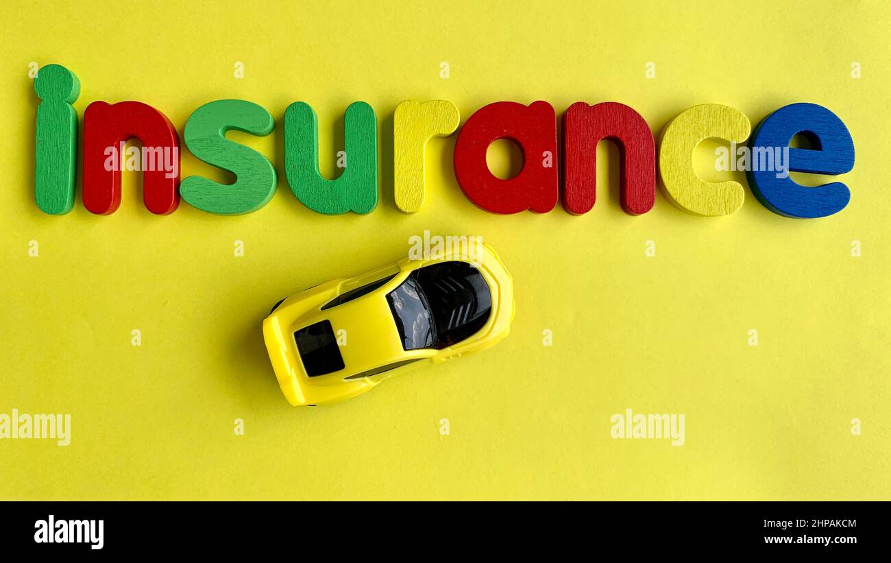 Top view of text of Insurance and model car with yellow background ...