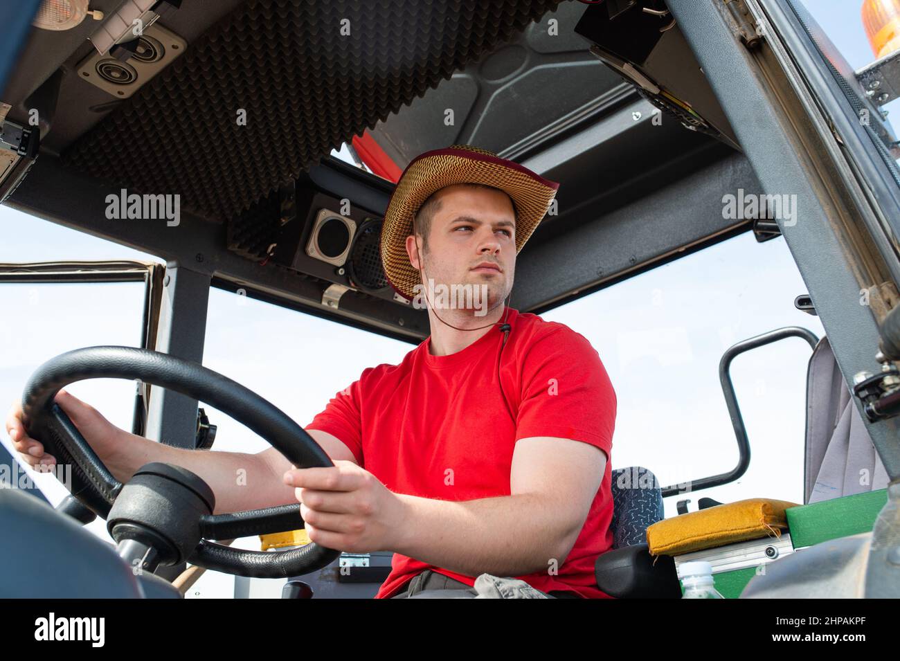 Young farmer driving his tractor Stock Photo - Alamy