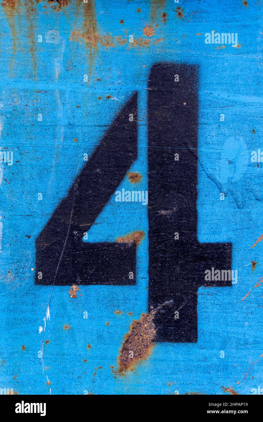 Number 4 in black paint on an old blue iron surface with rust texture ...