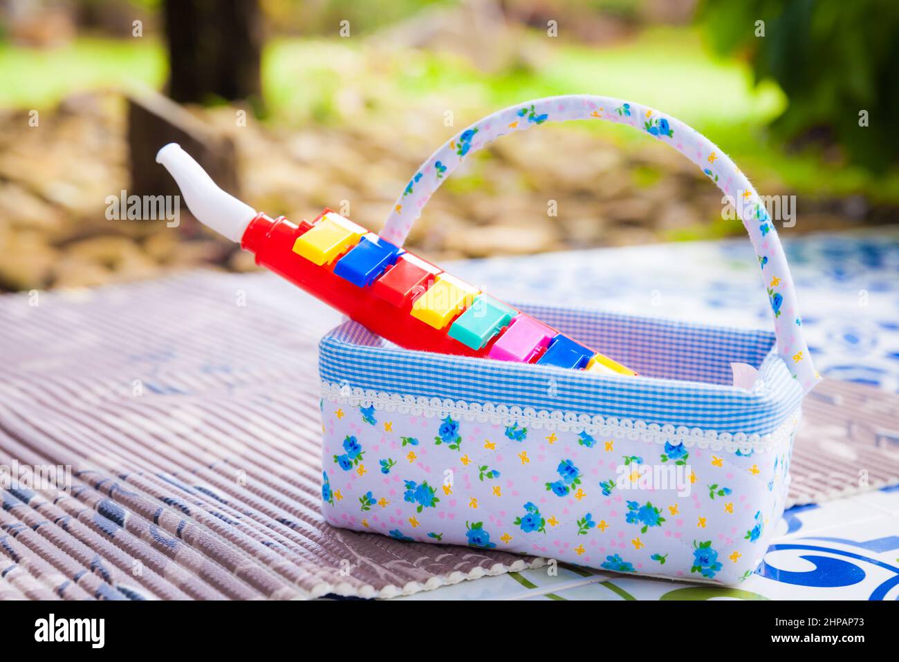 Plastic toy music pipe in basket prepared for kids over blur nature ...