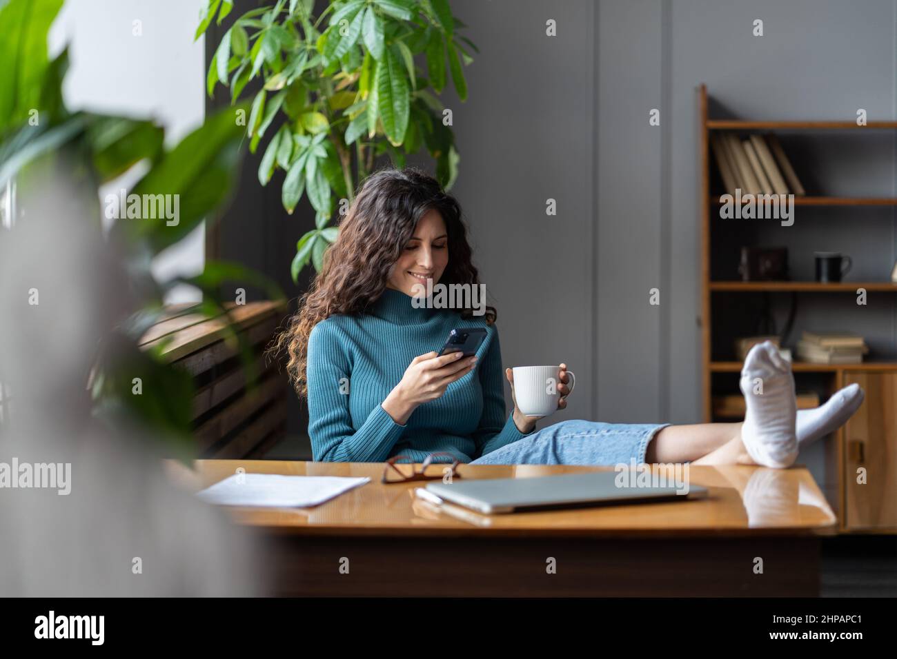Smartphone addiction at work. Female employee with smartphone enjoying ...
