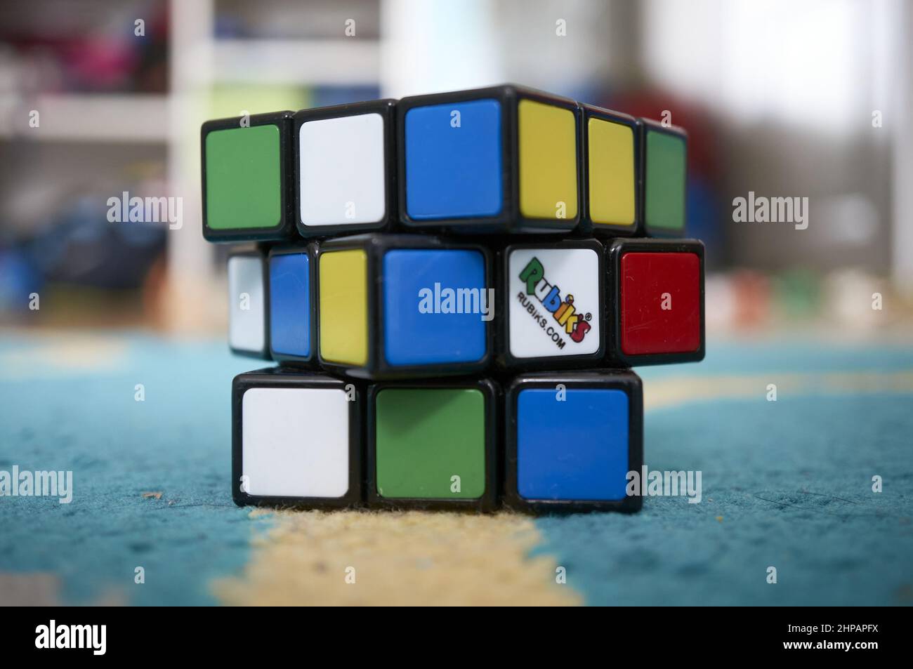 Close-up shot of a colorful unsolved Rubik's cube on a floor in a playroom Stock Photo - Alamy