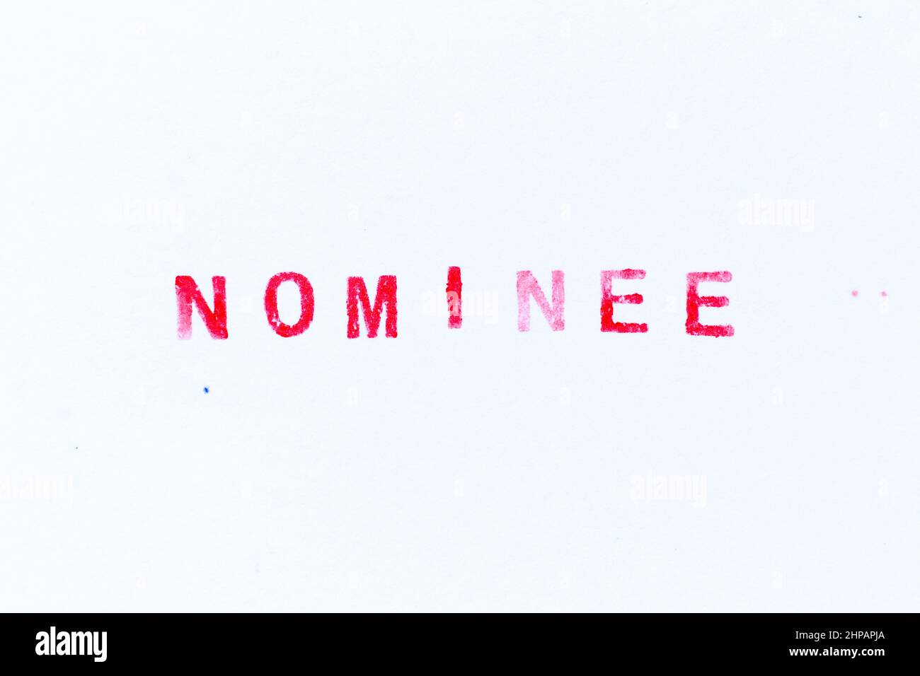 Red color ink rubber stamp in word nominee on white paper background ...