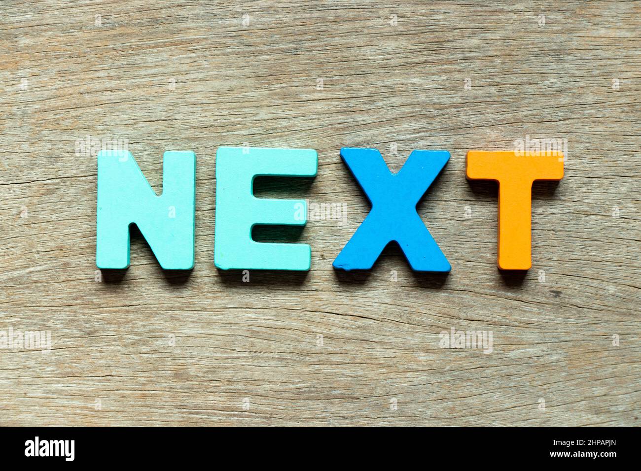 Color alphabet letter in word next on wood background Stock Photo - Alamy