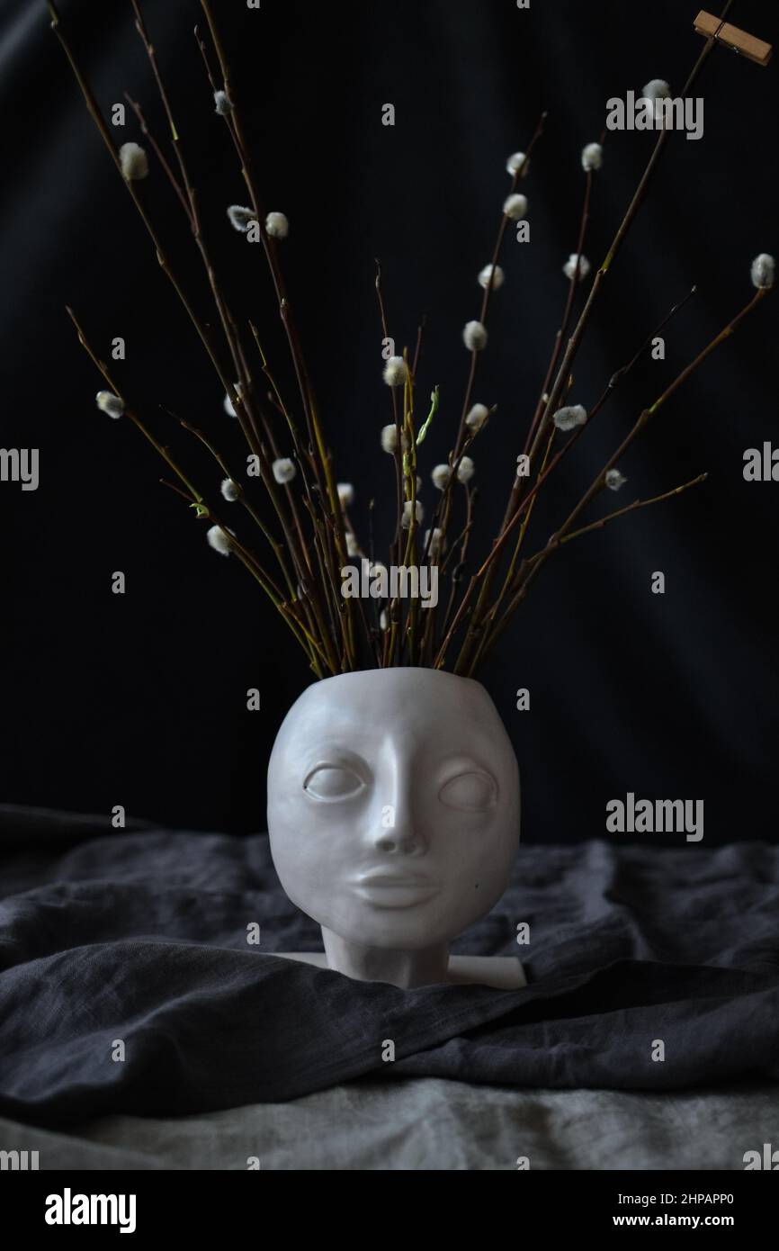 earthenware vase in the shape of a human face with willow Stock Photo ...