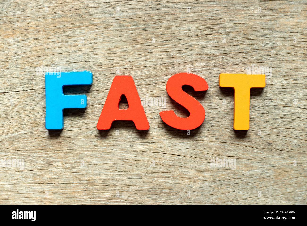 Color alphabet letter in word fast on wood background Stock Photo - Alamy