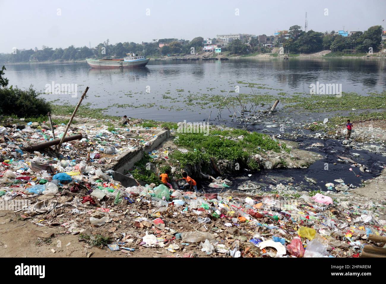 Children play on the banks of a polluted river. Shitalakshya river in ...