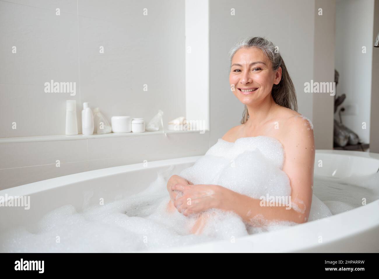 Positive adult woman resting after work in spa Stock Photo - Alamy