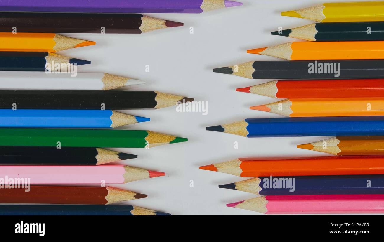 Many colored pencils are arranged around the edges of the image as a ...