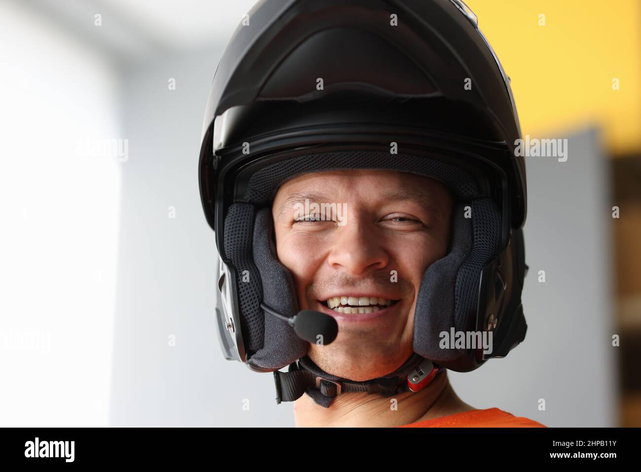 Smiling man in motorcycle helmet with speakerphone Stock Photo - Alamy