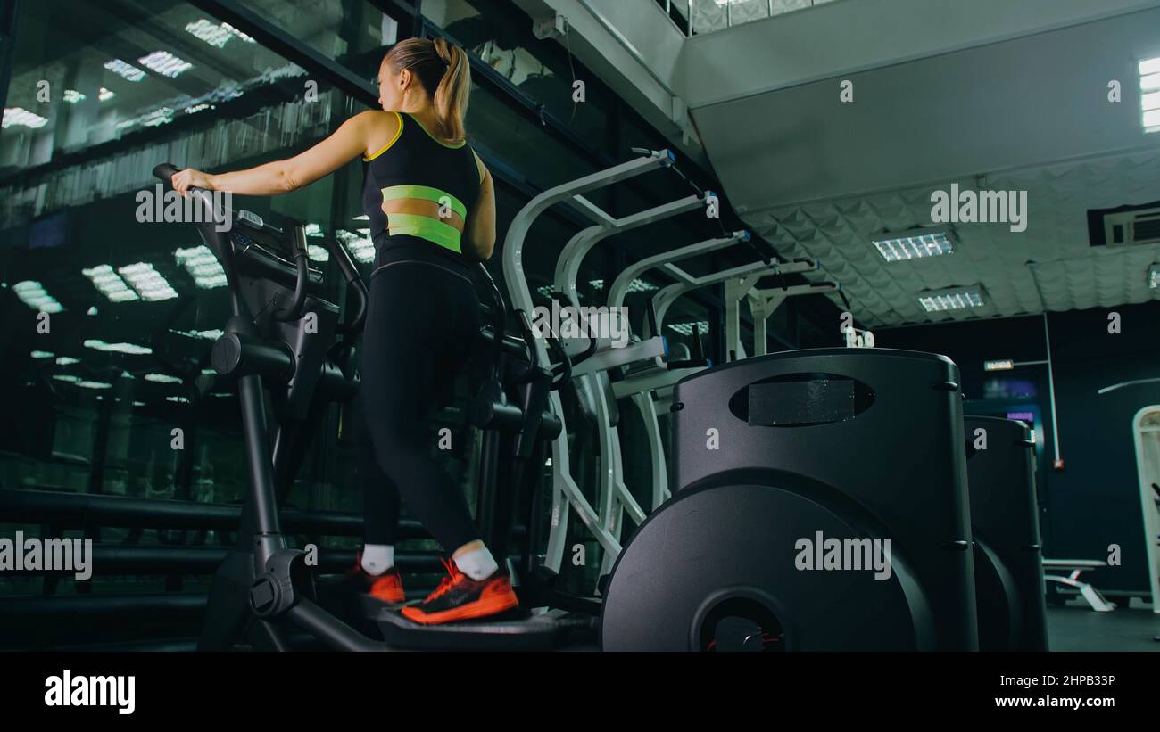 Fit Athletic Woman Exercising on an Elliptical Machine. Muscular Women ...