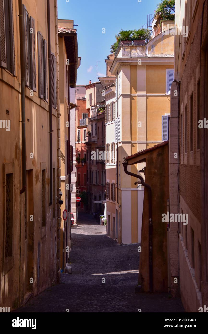 Vertical of a narrow empty street between old buildings in Rome, Italy ...