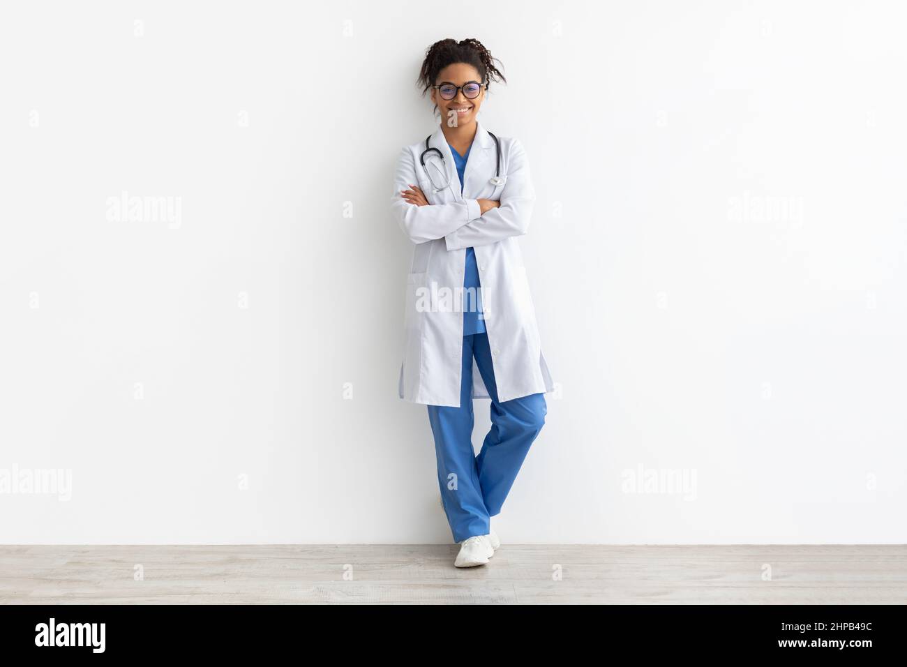 Portrait of black doctor posing with folded arms Stock Photo - Alamy