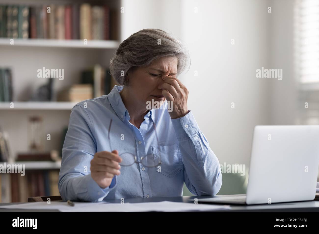 Tired middle aged woman taking off eyeglasses, suffering from pain ...