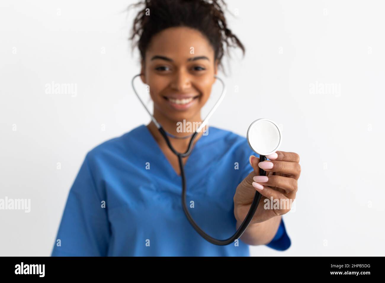 Portrait of black doctor smiling and showing stethoscope Stock Photo ...