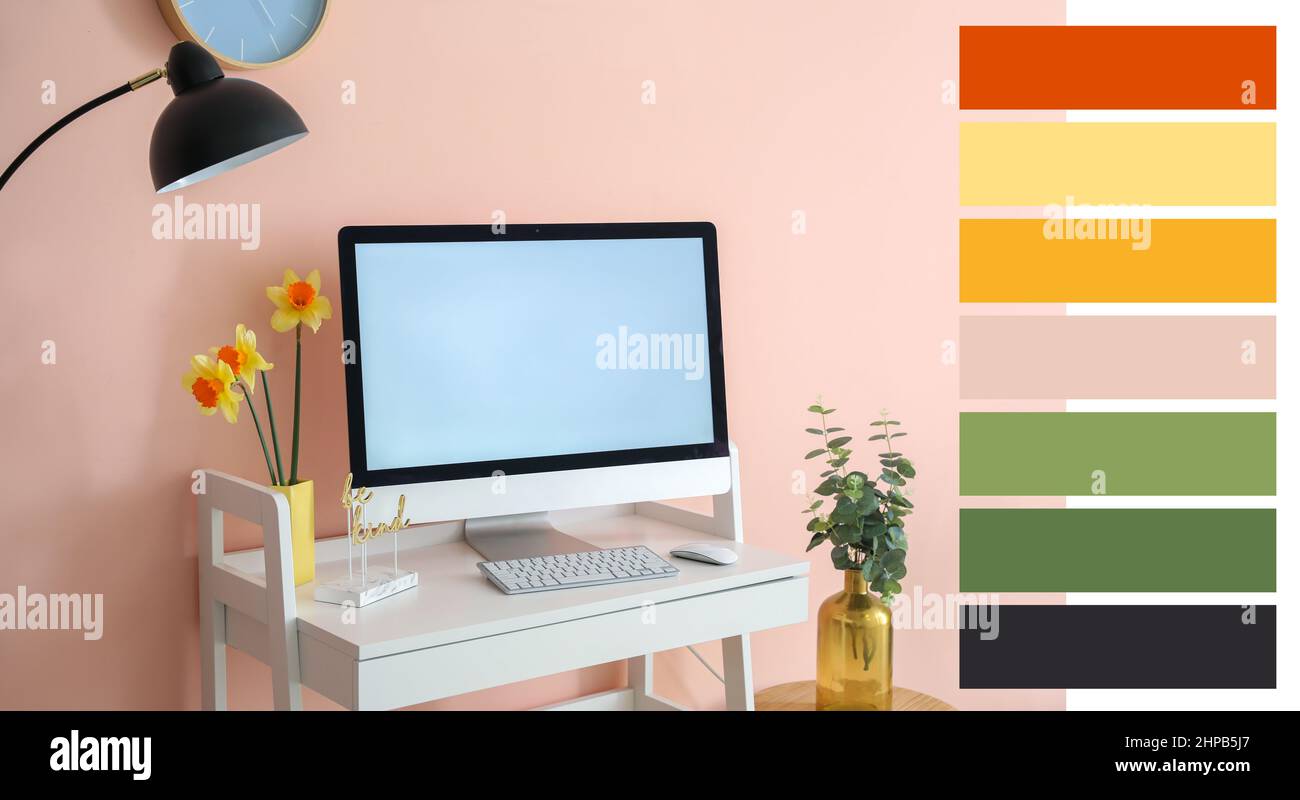 Modern workplace with computer monitor and narcissus flowers in room ...