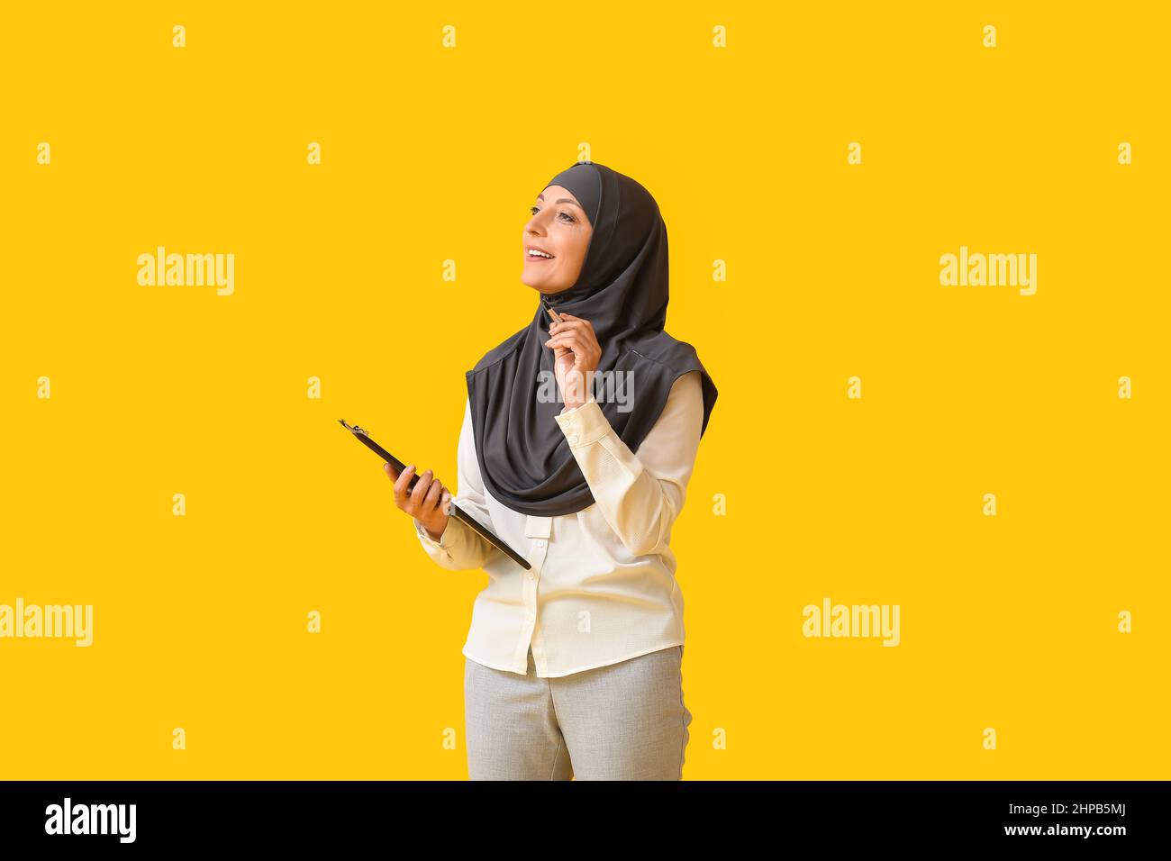 Portrait of Muslim secretary with clipboard on color background Stock ...