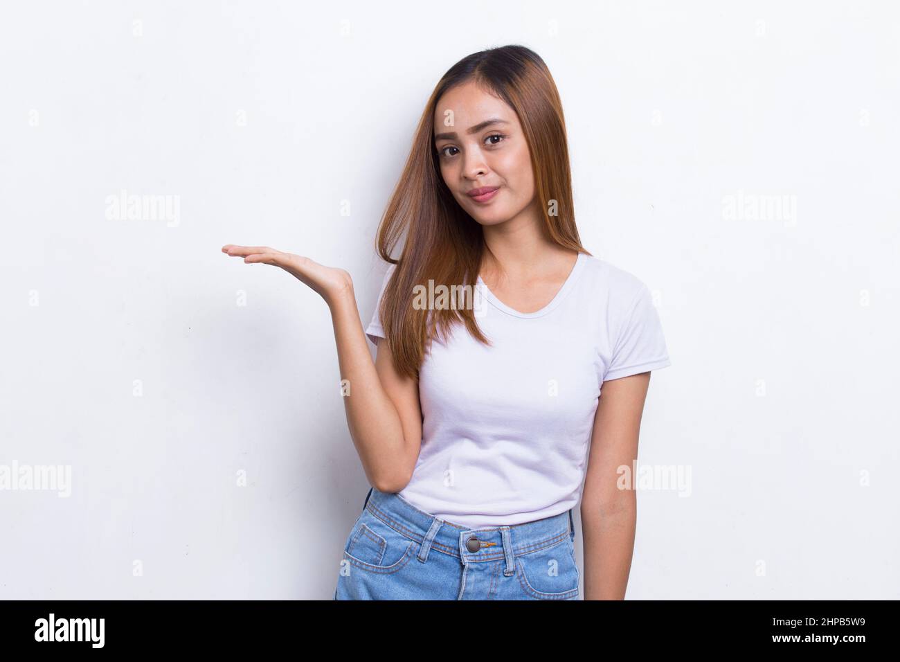 Happy young asian woman pointing with fingers to different directions ...