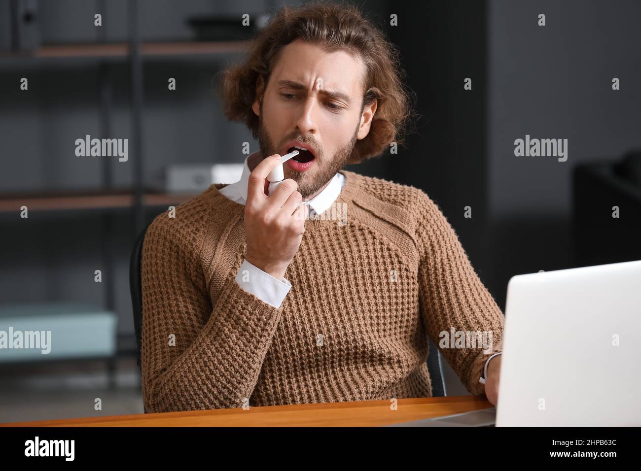 Ill man with inhaler in office Stock Photo - Alamy