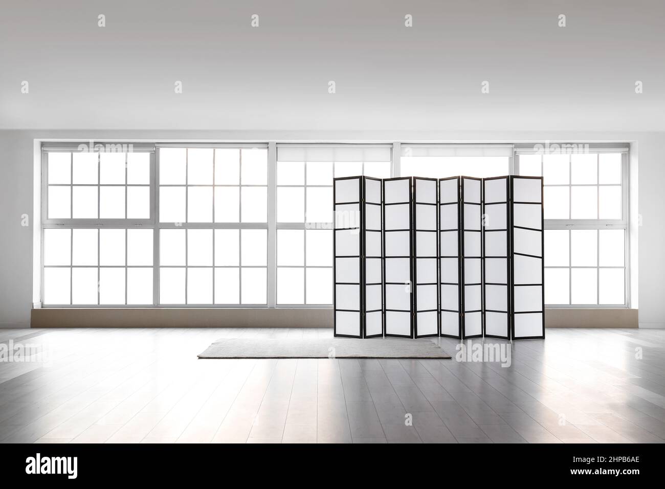 View of empty room with windows, folding screen and carpet Stock Photo ...
