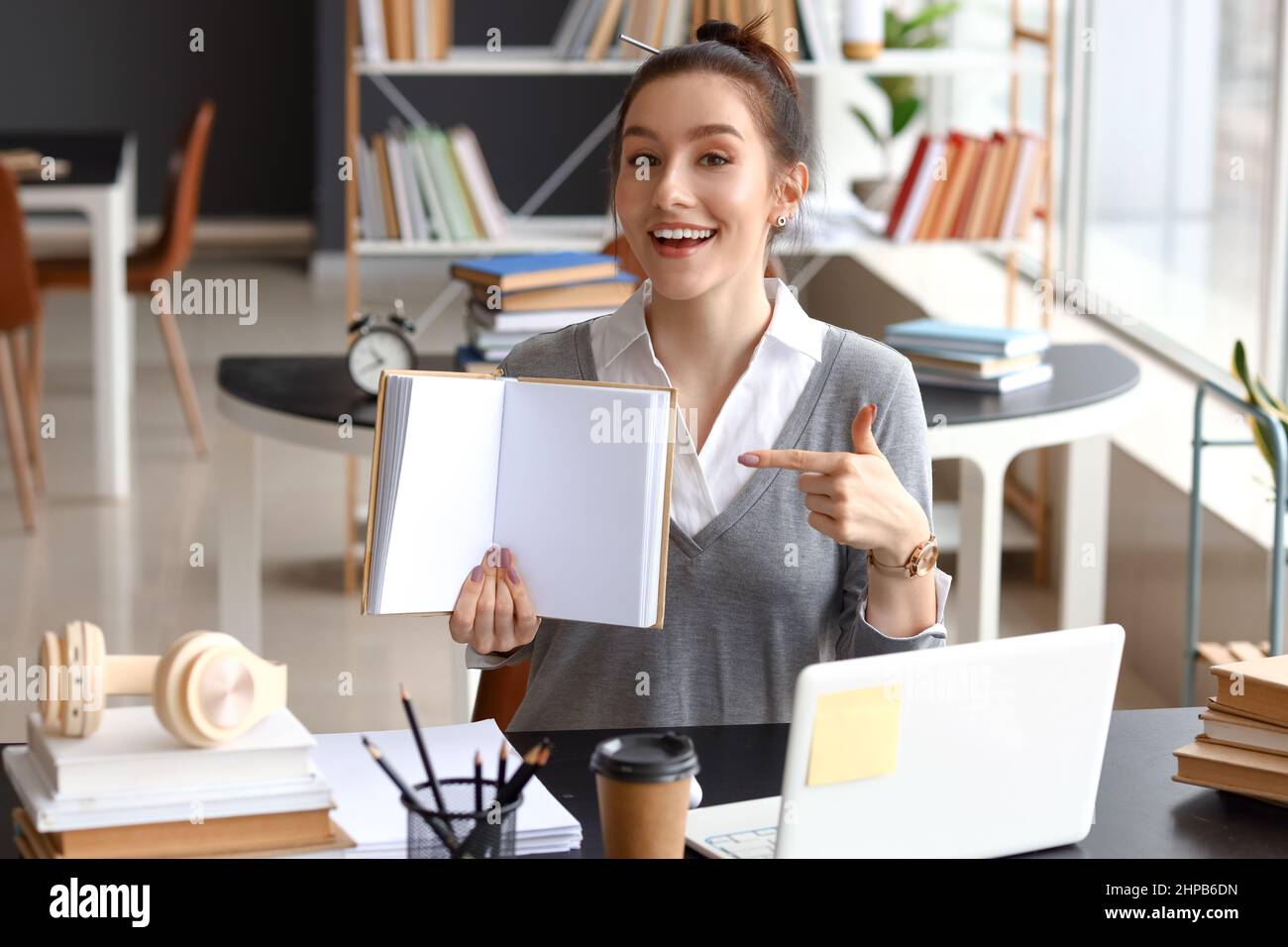 Beautiful young woman studying in library Stock Photo - Alamy