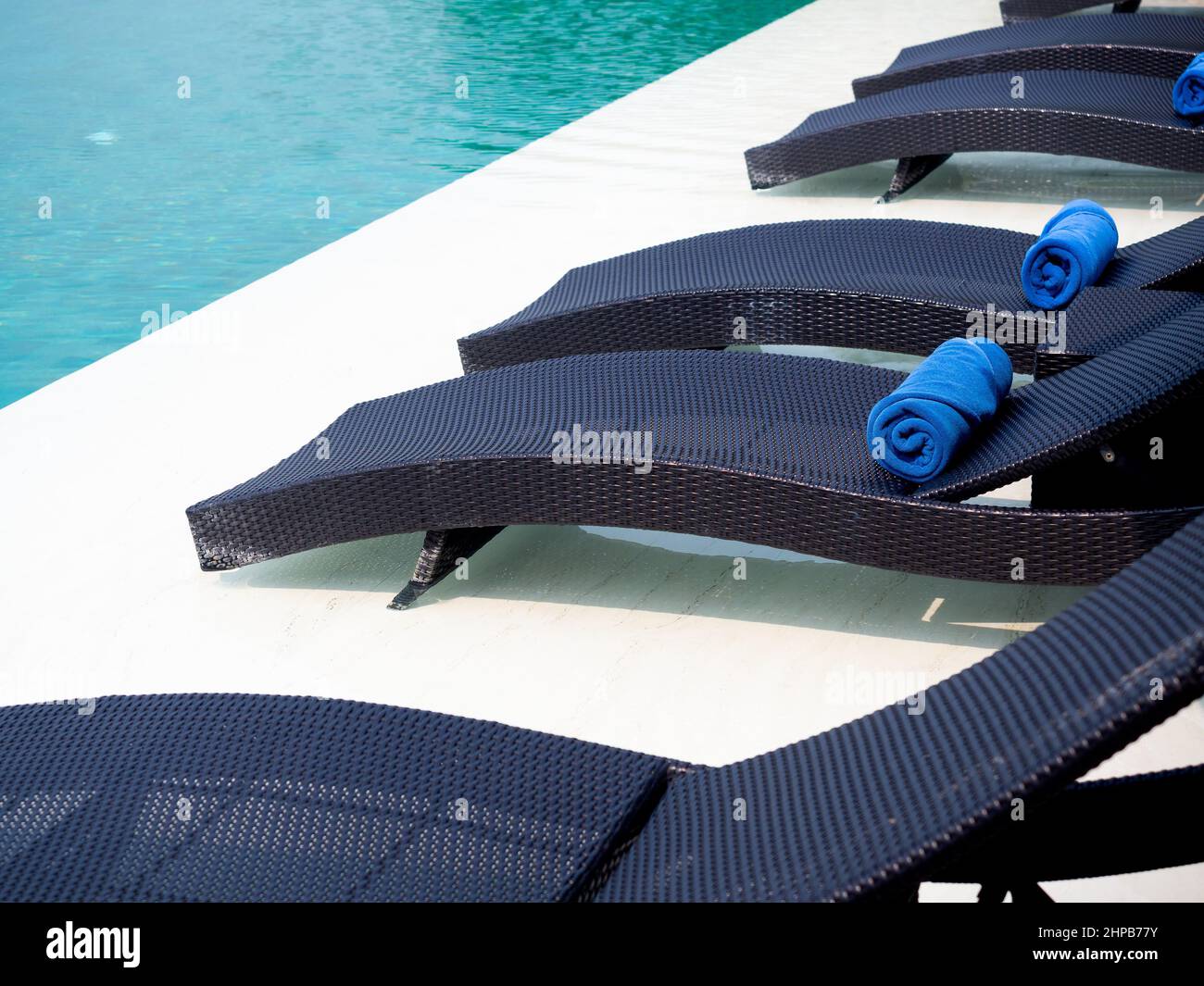 Blue towel pool for the guest on the empty modern rattan sunbed on ...