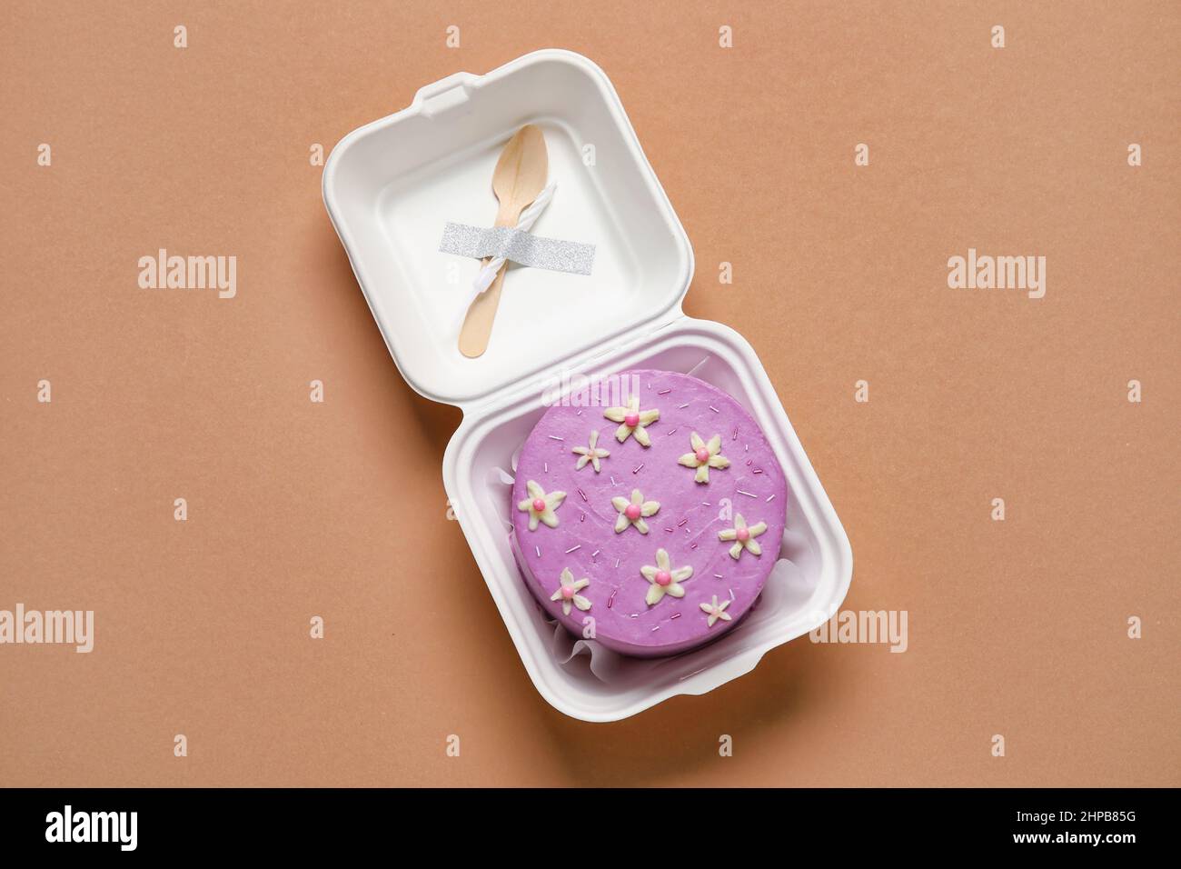 Plastic lunch box with tasty bento cake on brown background Stock Photo ...