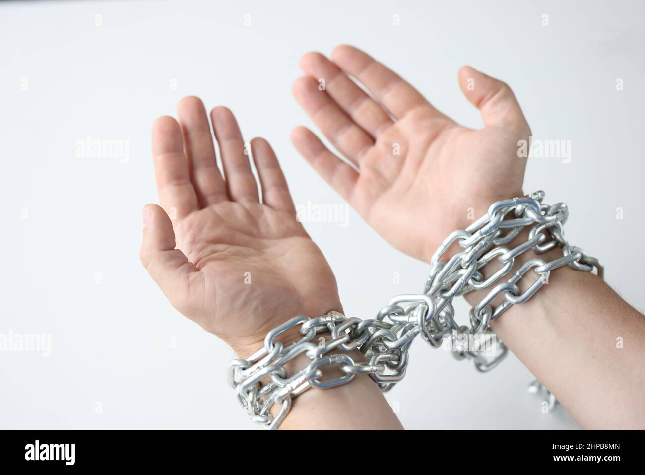 Man hands are tied with chain on white background Stock Photo - Alamy