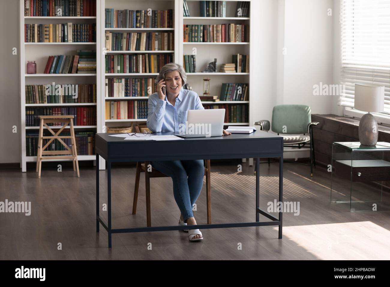 Happy senior entrepreneur multitasking at home office Stock Photo - Alamy