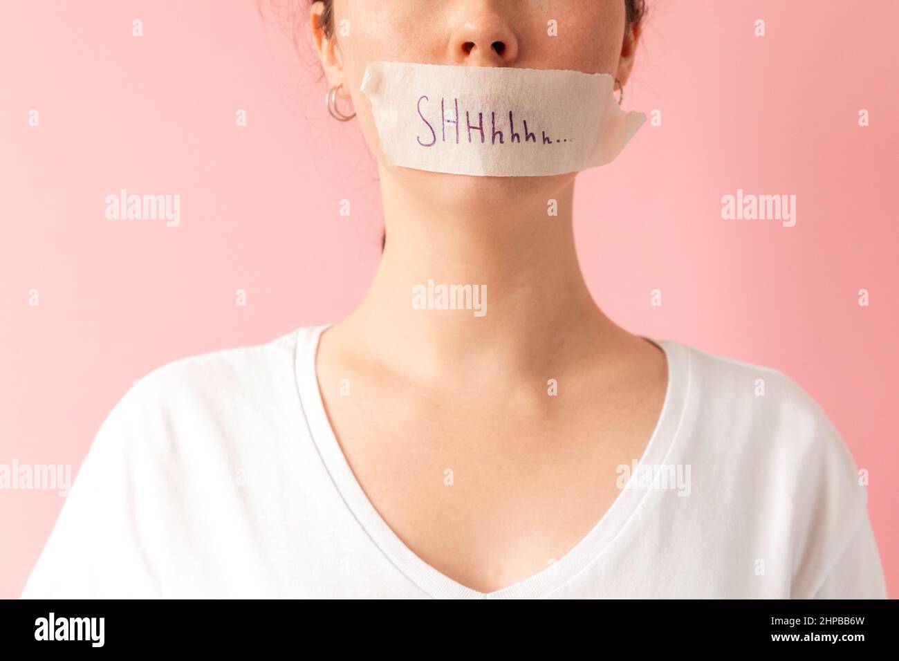 Close up of caucasian woman's face with her mouth taped shut. Tape has ...