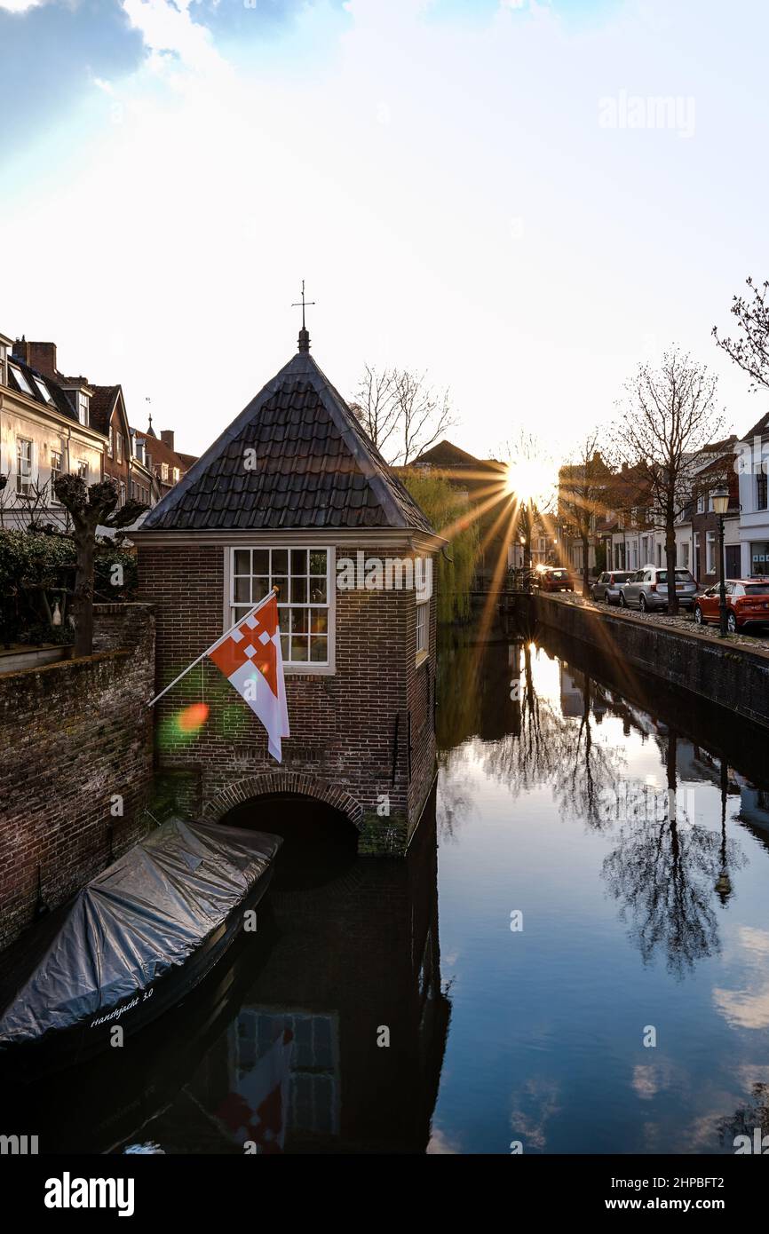 Vertical shot of a water canal flowing next to some old buildings Stock ...