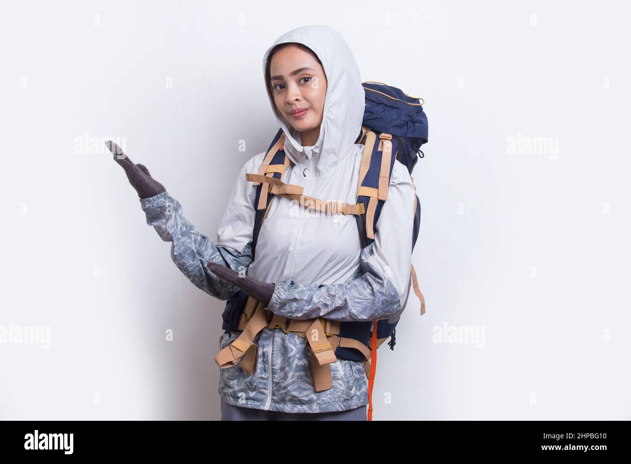 Young asian hiker woman with backpack pointing finger on empty space on ...