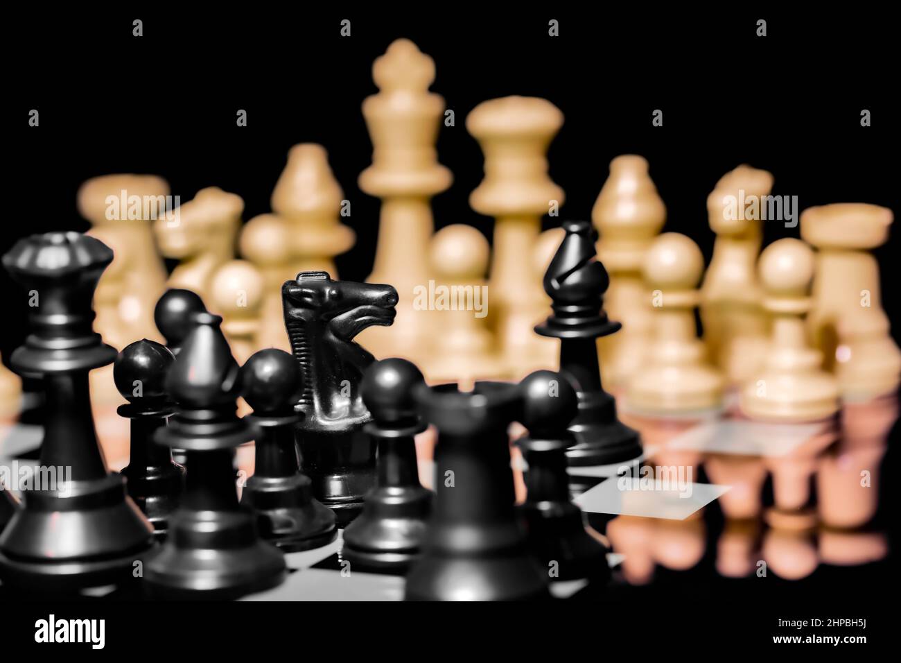 Close up of Chess pieces on a reflective mirror board surface with a ...